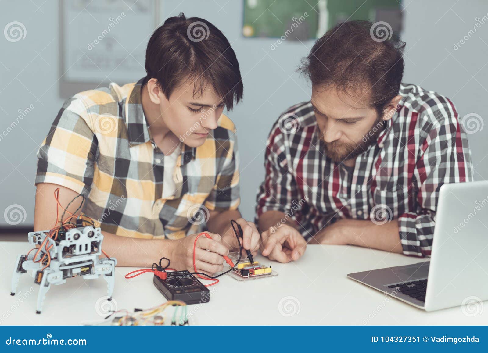 The Guy and the Man Examine the Board Using a Multimeter. they Measure ...