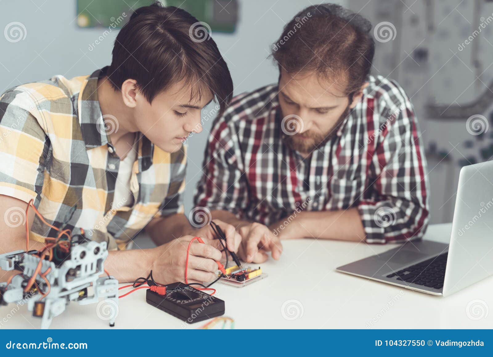 The Guy and the Man Examine the Board Using a Multimeter. they Measure ...