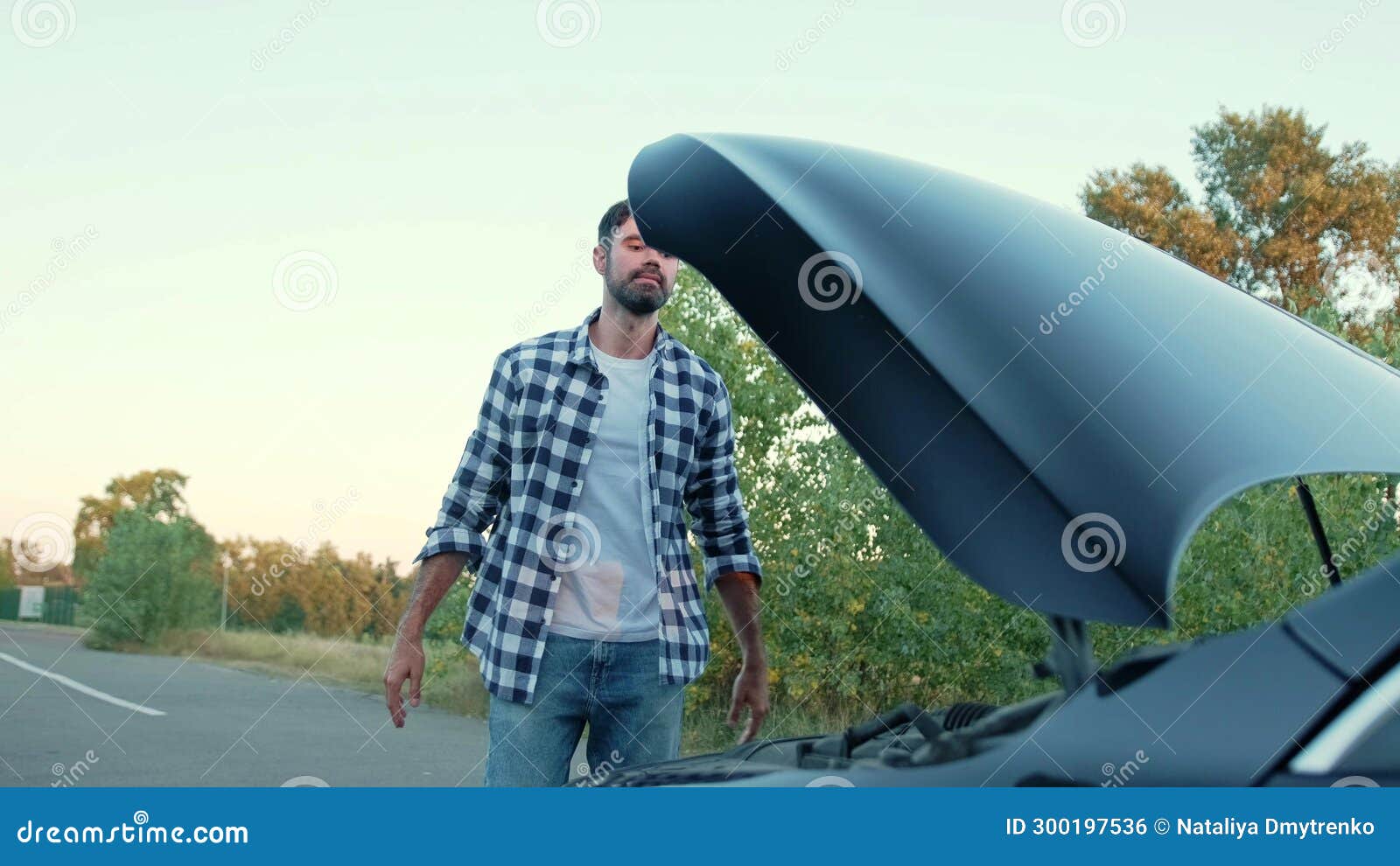 Guy Opening Car Hood and Leaning on the Hood of a Broken Car on the ...