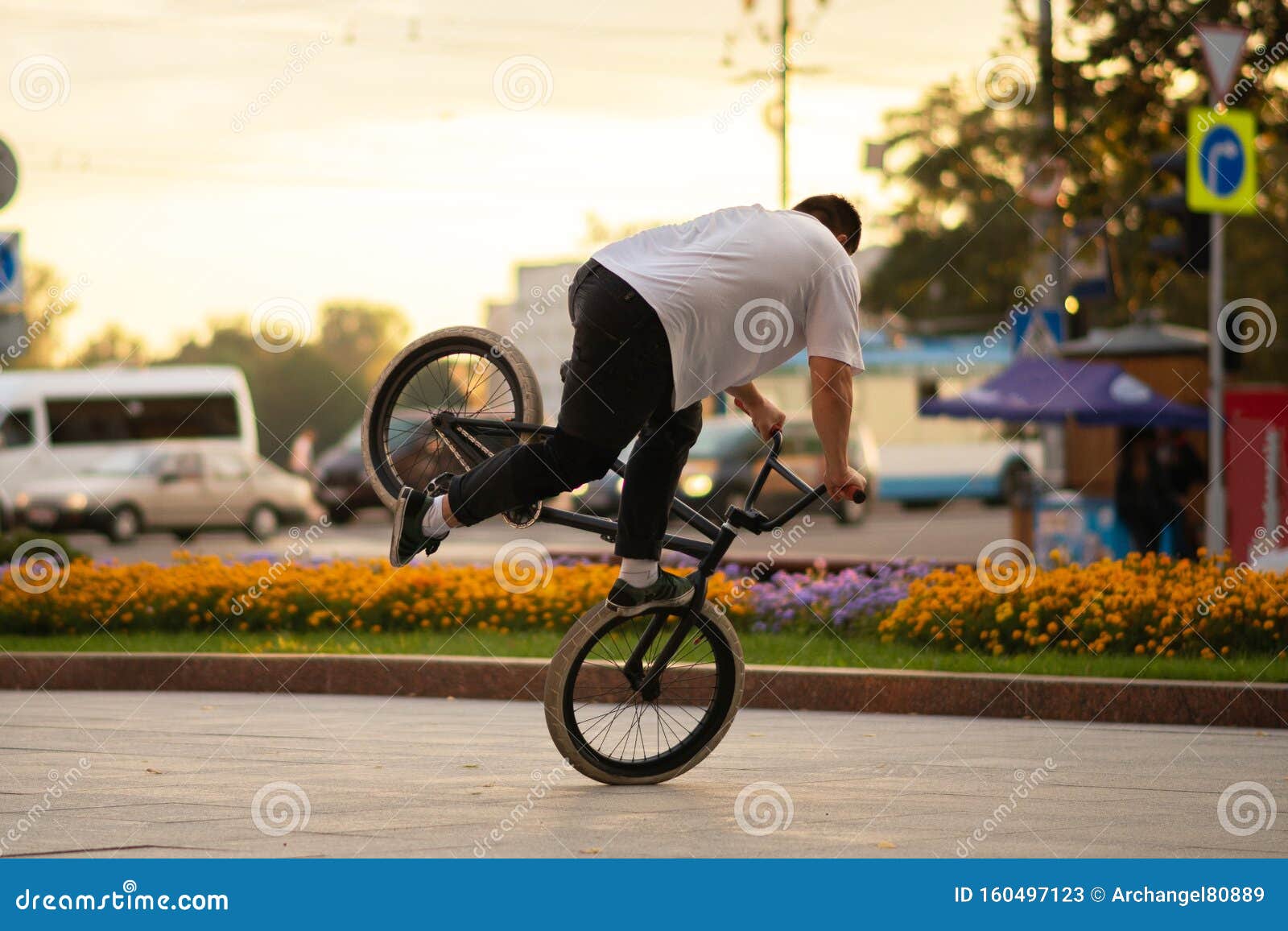 The Guy Performs a Stunt on BMX, Standing on the Front Wheel Stock ...