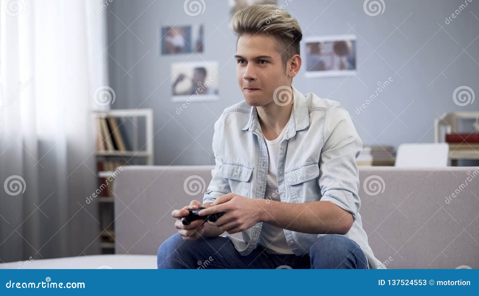 Guy Playing Computer Game with Controller, Worried about Winning ...