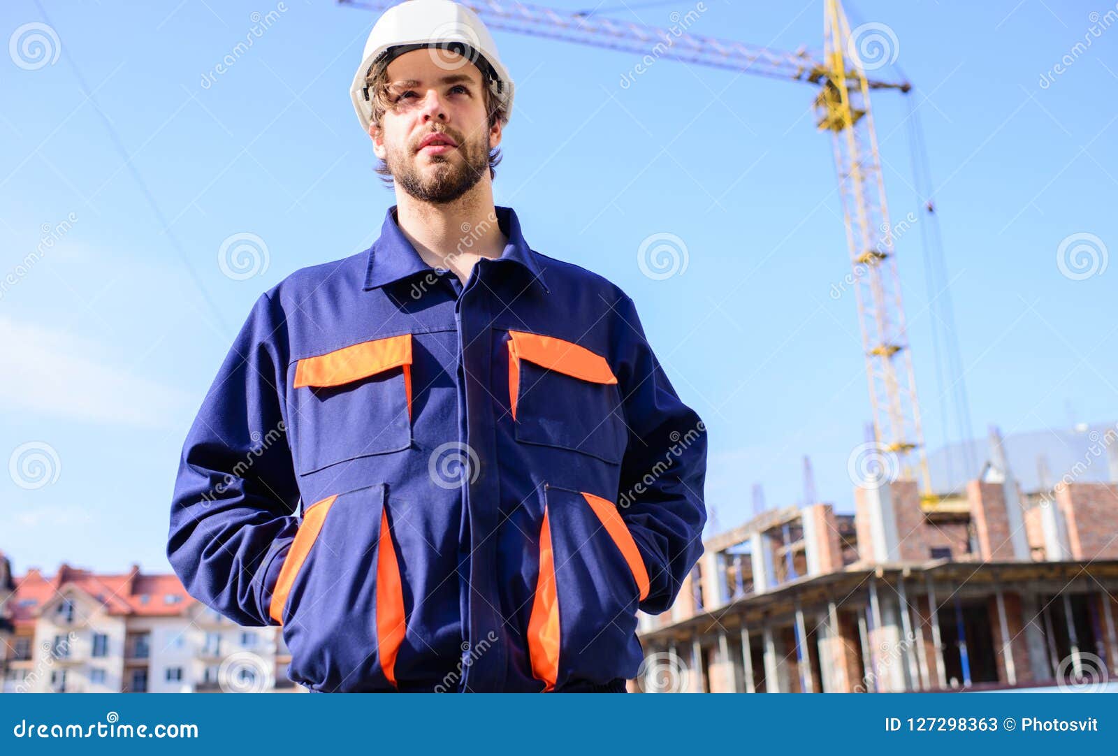 Guy in Protective Helmet Stand in Front of Building and Crane. Control ...