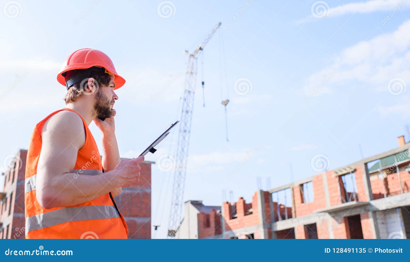 Guy Protective Helmet Stand in Front of Building Made Out of Red Bricks ...
