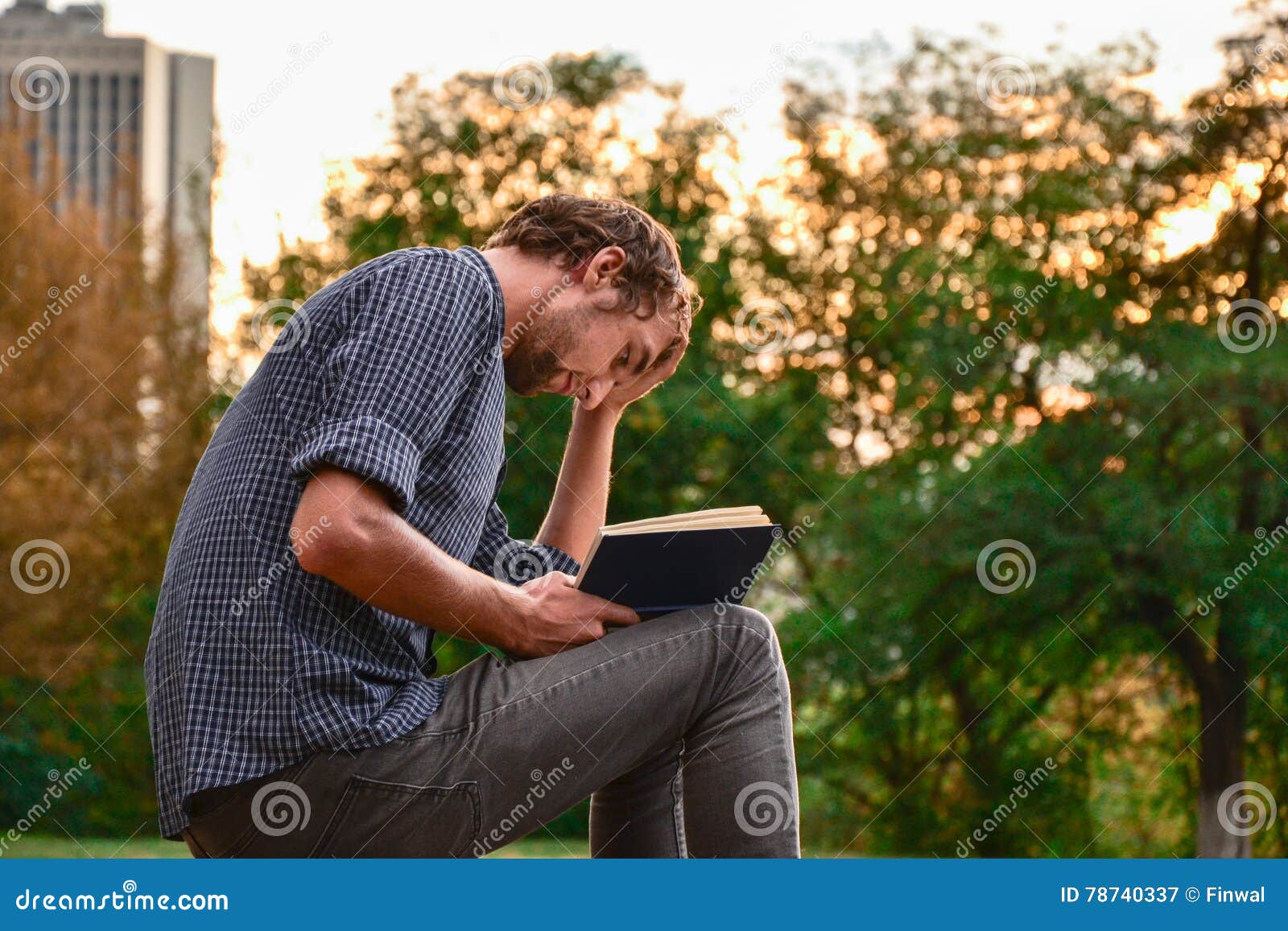 Guy reading book in park stock image. Image of cute, reading - 78740337
