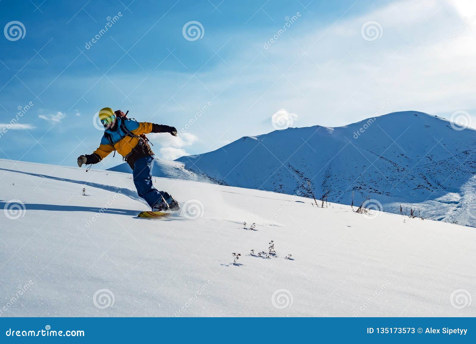 The Guy is Riding a Snowboard. in the Mountains in Pristine Snow Stock ...
