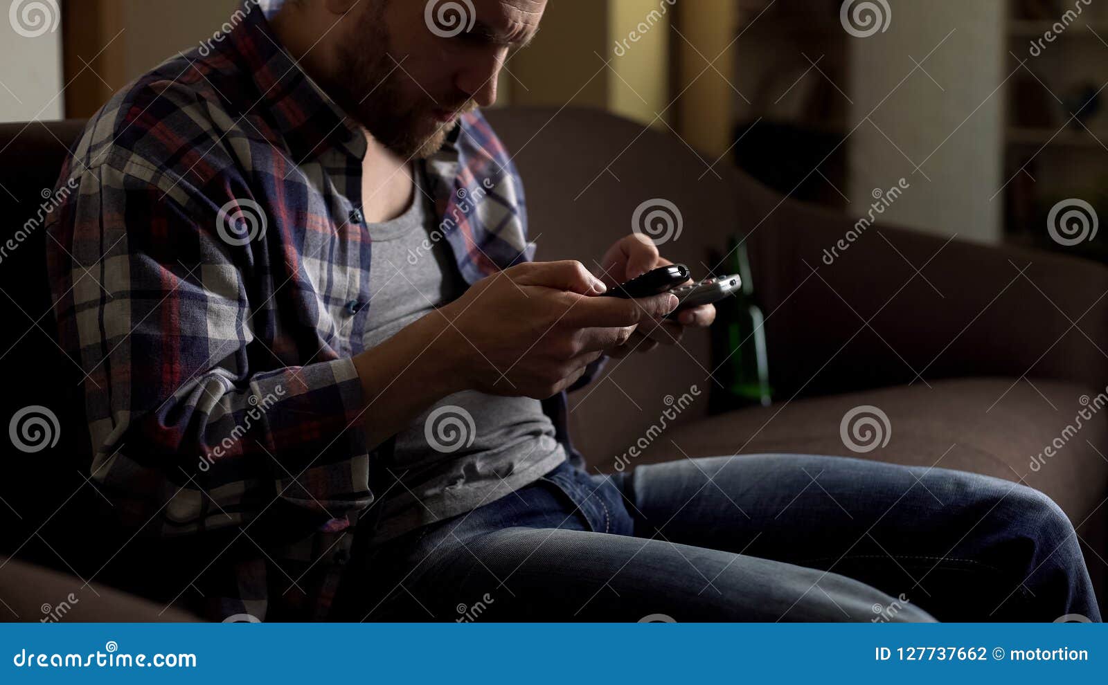 Guy Sitting on Couch, Using Remote Control for TV Set, Getting Angry ...
