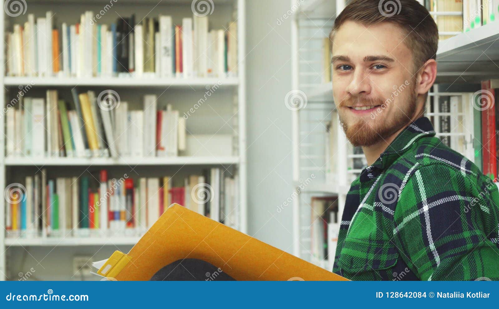 A Laughing Guy is Sitting in the Library and Reading Stock Photo ...