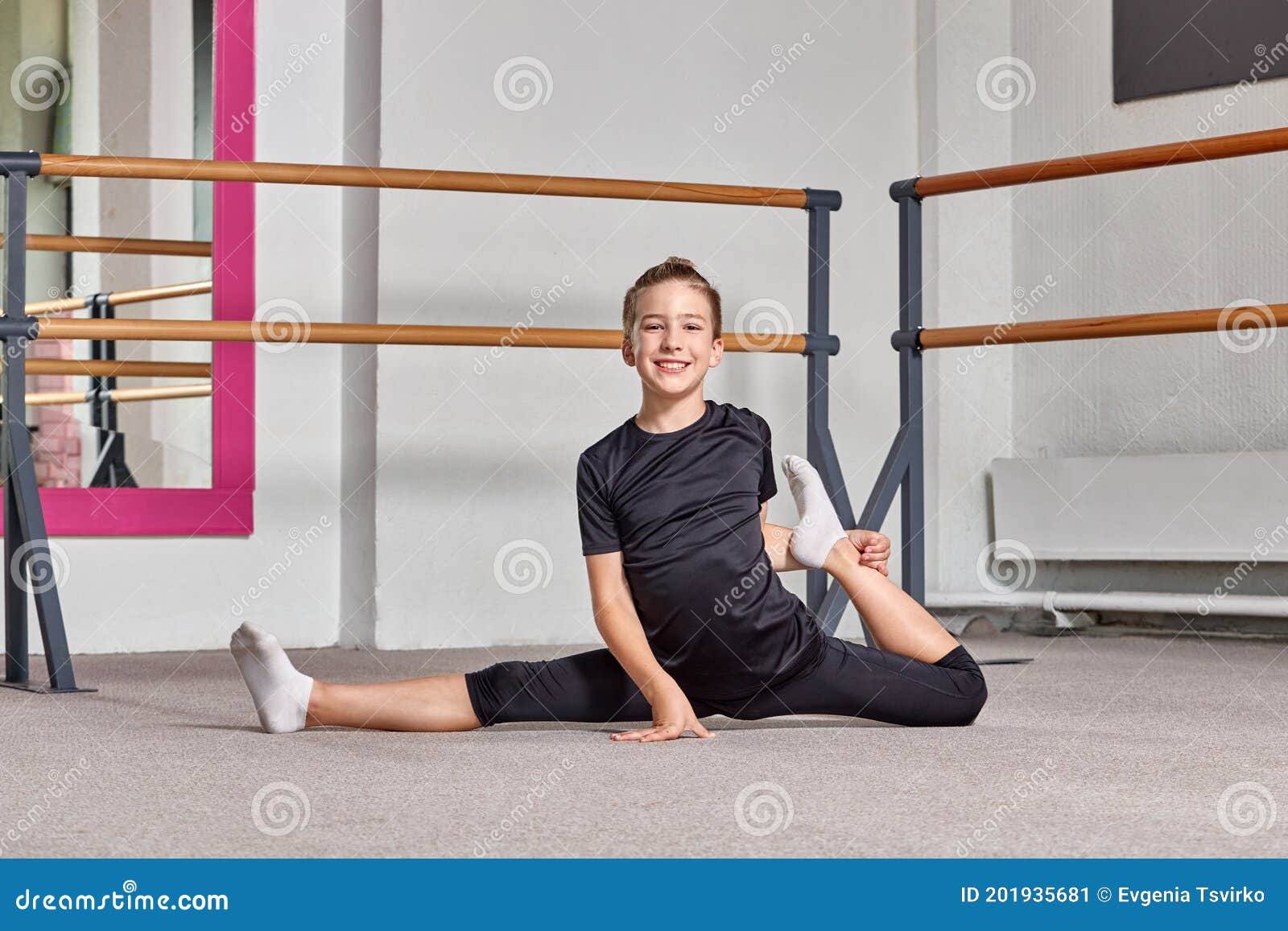 A Guy is Sitting on the Floor on the Splits, Smiling and Looking at the ...