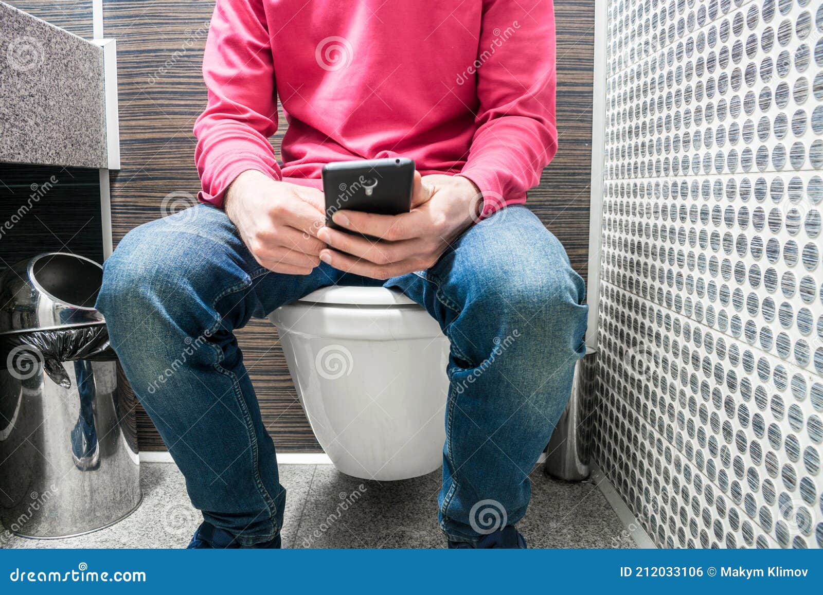 The Guy is Sitting on the Toilet with the Phone in His Hands Stock ...