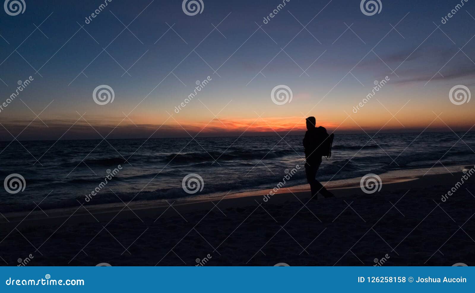 Guy Stands in Front of Dramatic Sunset Over the Ocean Stock Photo ...