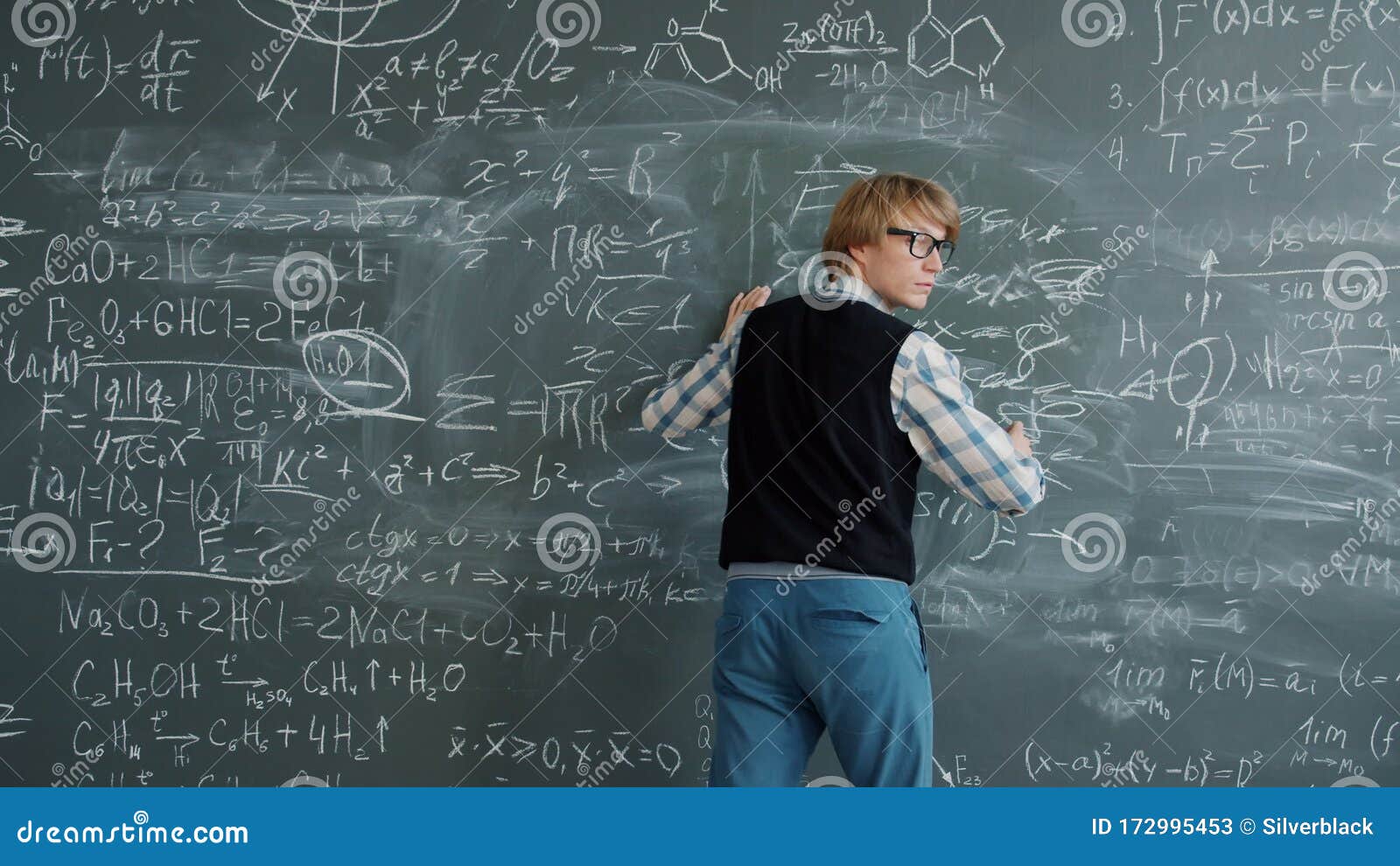 Guy Teacher Writing on Chalkboard Teaching Class while Students Having ...