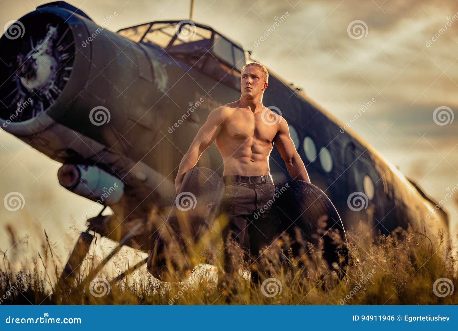 A Guy with Tires in His Hands is Standing by the Plane. Stock Photo ...