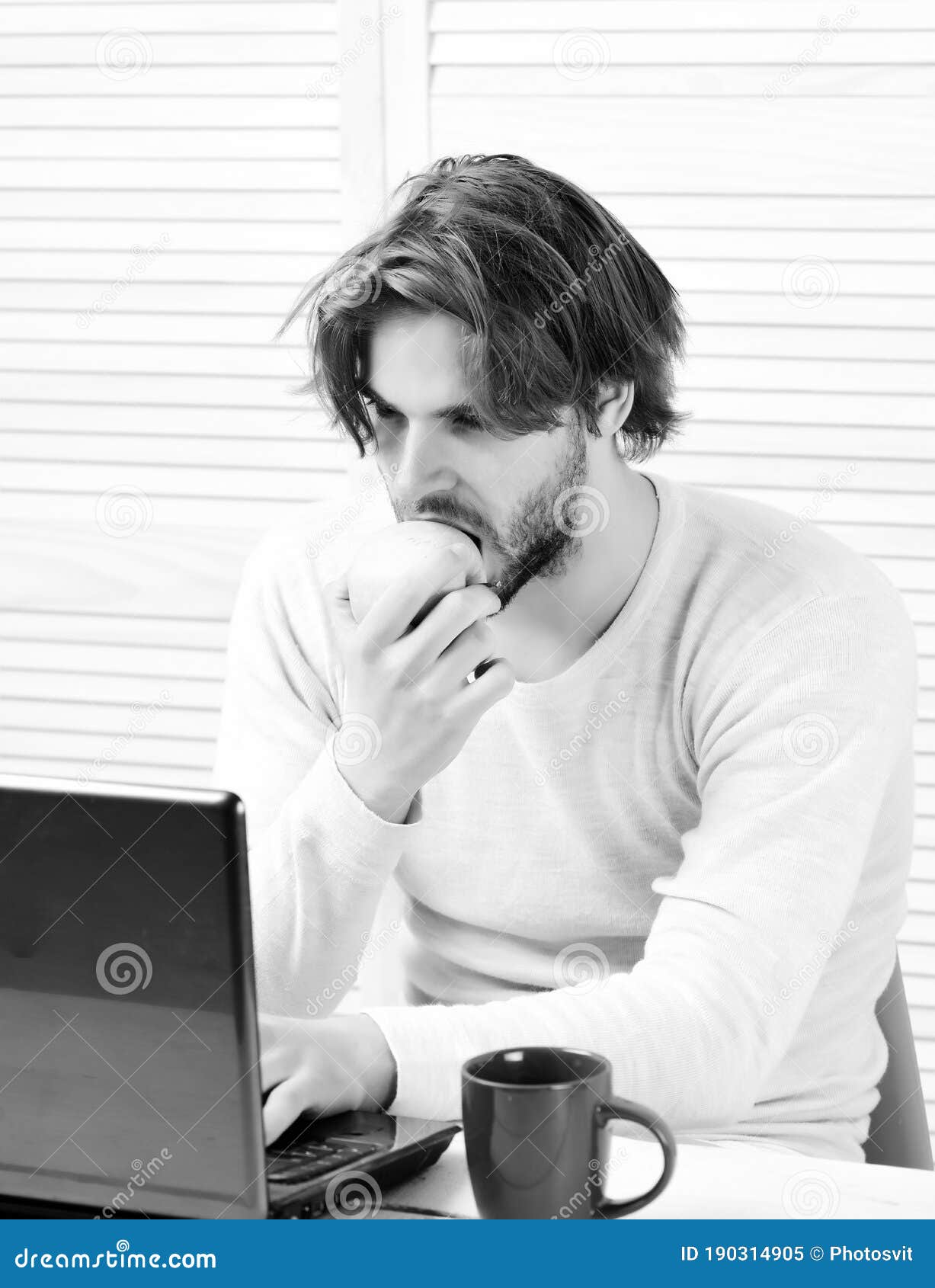 Guy Uses His Computer and Eats Apple. Man at Work Stock Image - Image ...