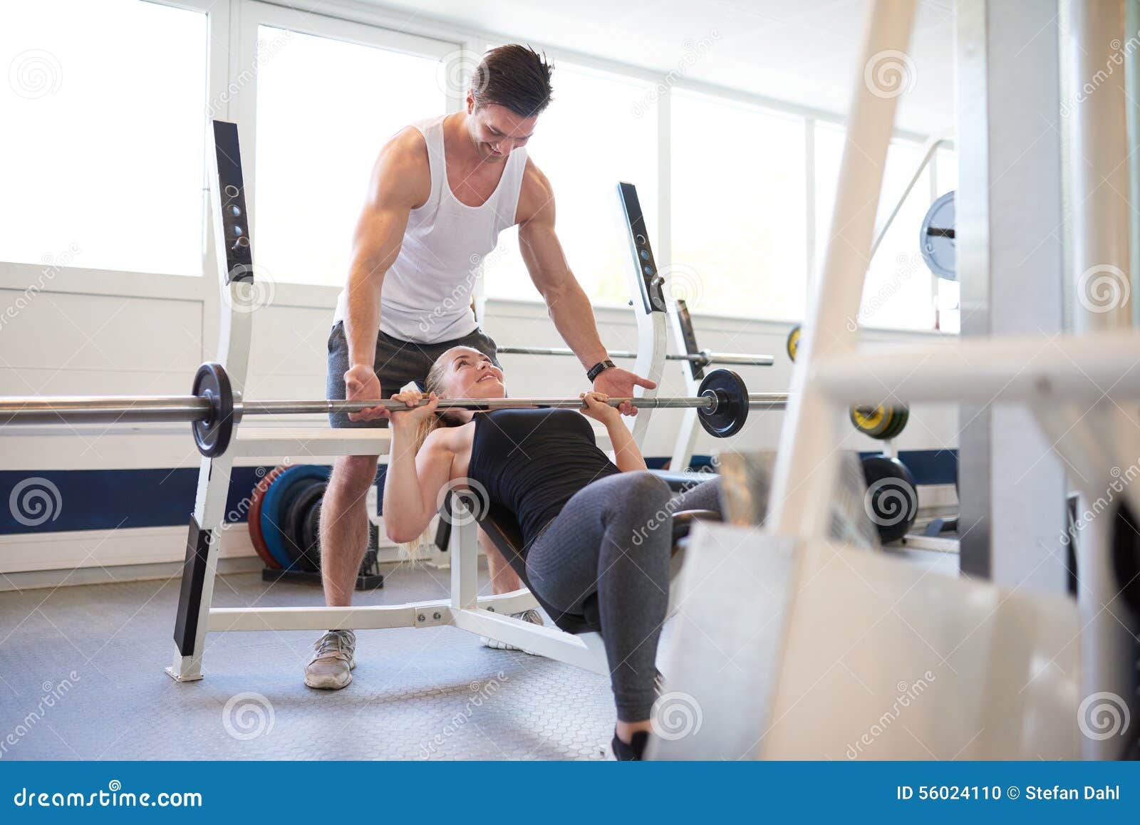 Gym Instructor Supporting Woman in Lifting Barbell Stock Photo - Image ...
