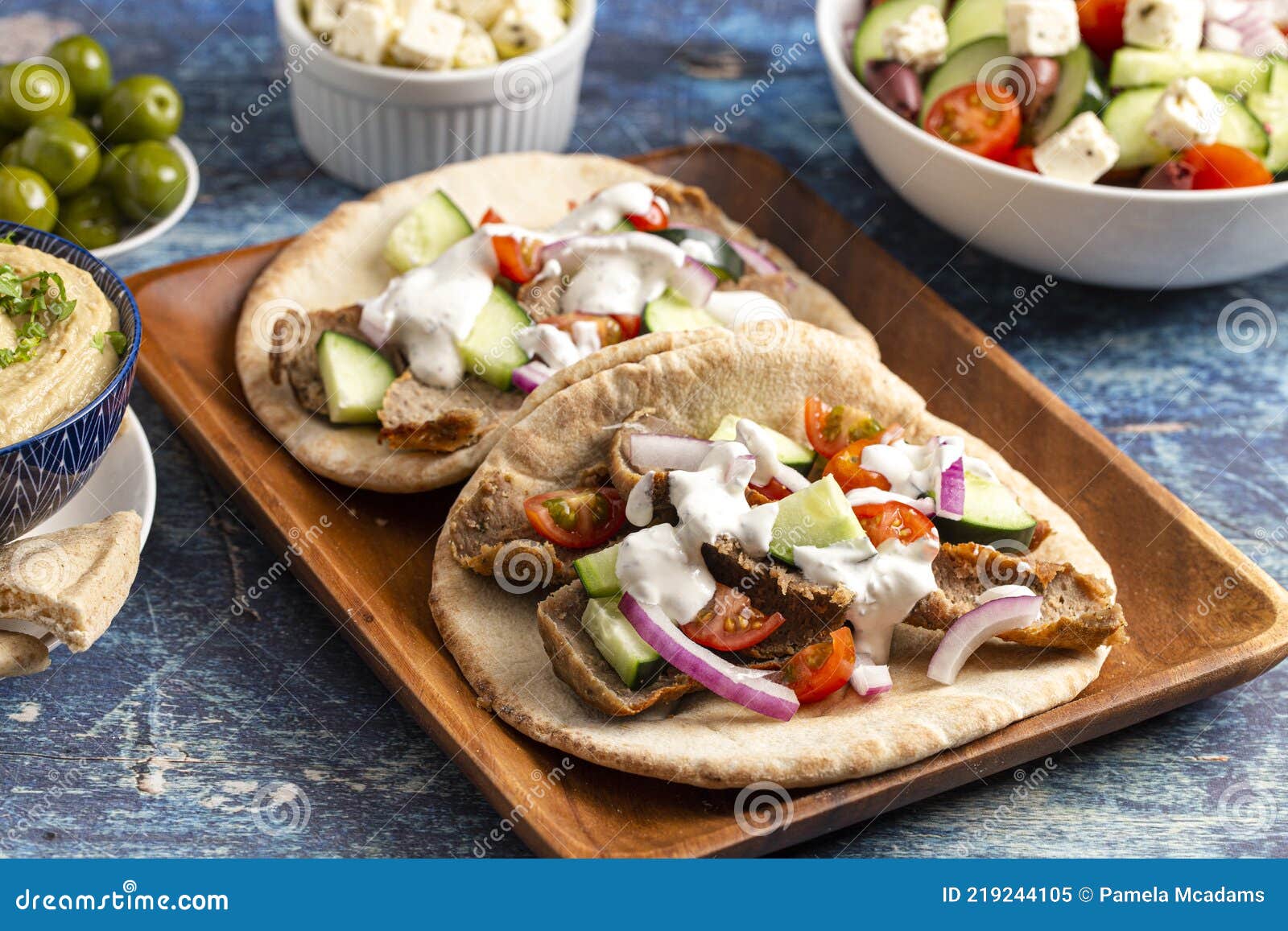 Gyros with Vegetables and White Garlic Sauce on a Rustic Wooden Table ...