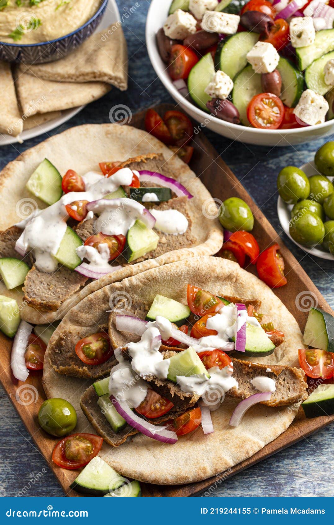 Gyros with Vegetables and White Garlic Sauce on a Rustic Wooden Table ...