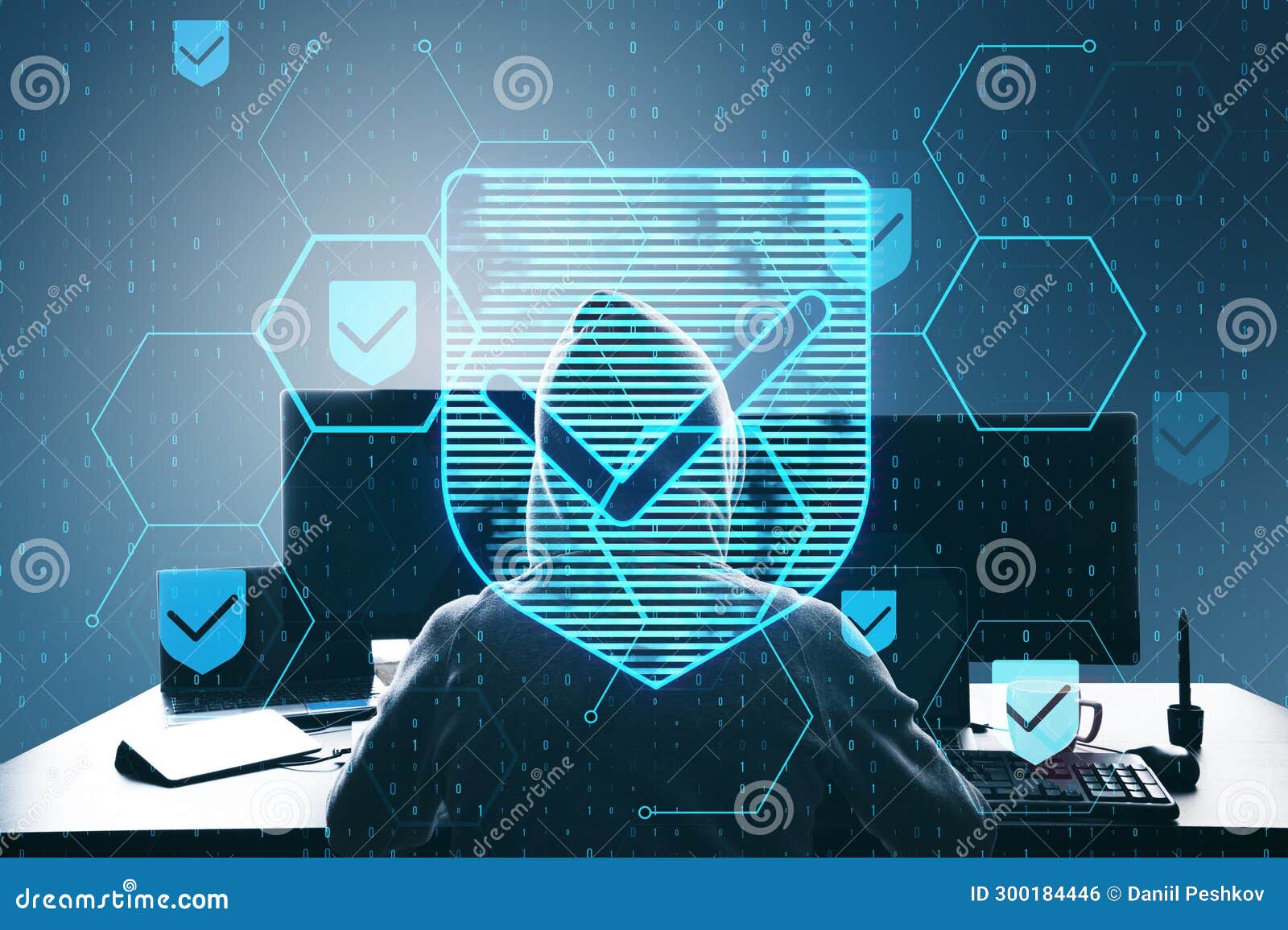 Hacker At Desktop Using Laptop With Glowing Hexagonal Shield Hologram With Binary Coding On