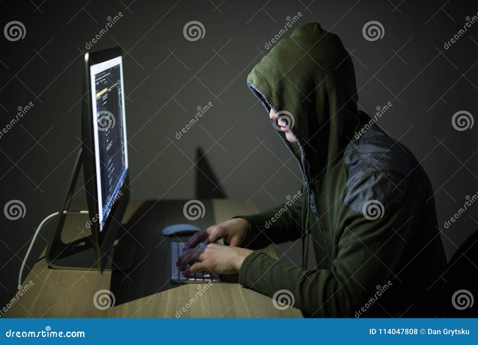 A Hacker in a Hood on a Dark Background Hacking Computer Networks in ...