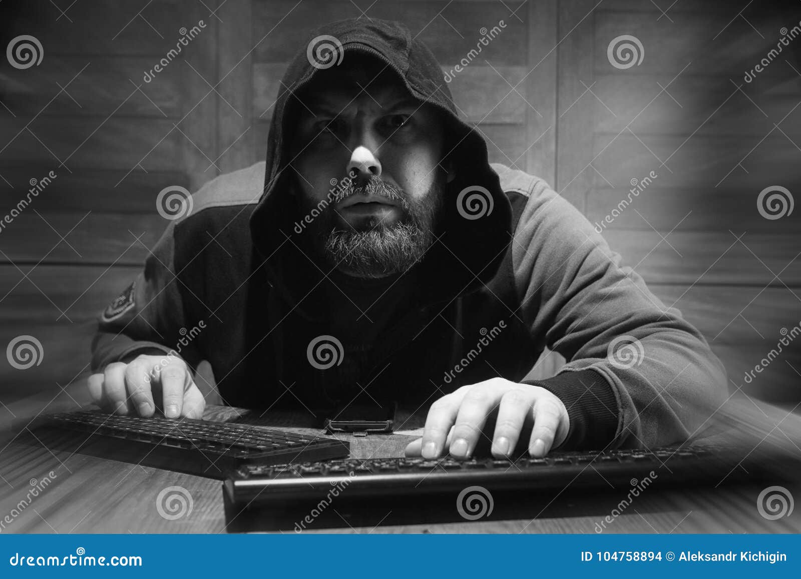The Hacker in the Hood Sits and Works Behind the Computer Stock Photo ...