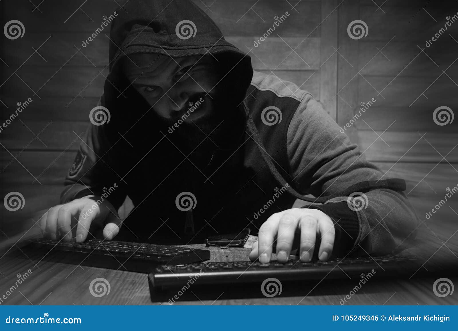 The Hacker in the Hood Sits and Works Behind the Computer Stock Photo ...