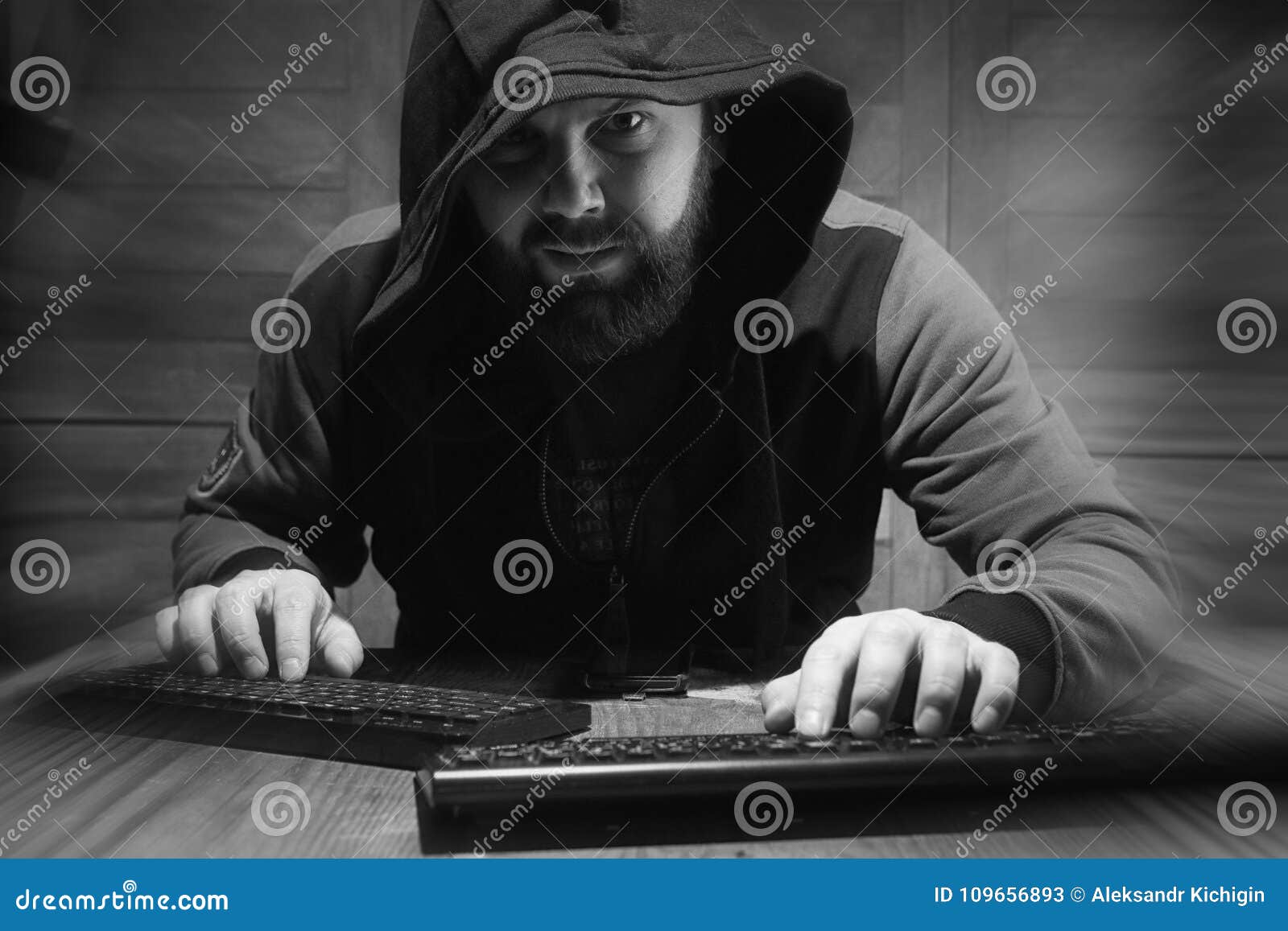 The Hacker in the Hood Sits and Works Behind the Computer Stock Image ...