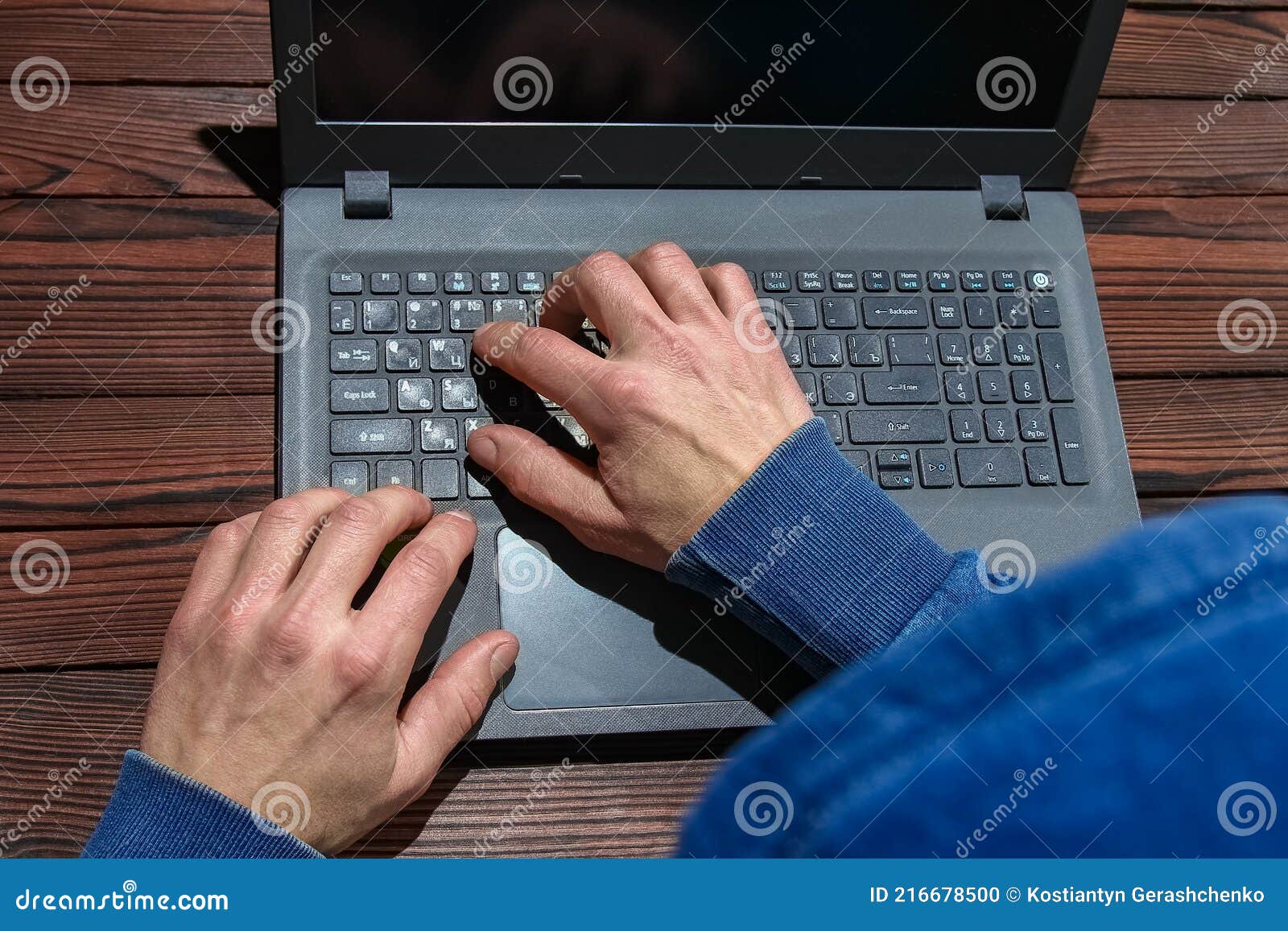 A Hacker with Laptop Sits at a Table and Abstract Binary Code. Business ...