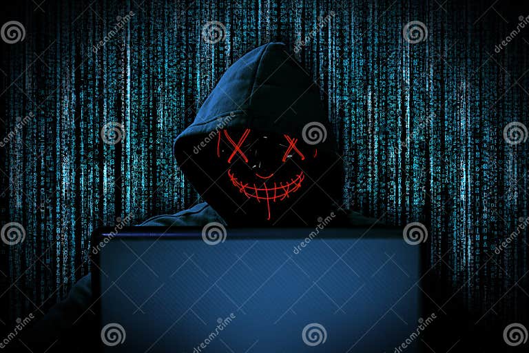 Hacker with Red Glowing Mask Behind Notebook Laptop in Front of Blue Source Binary Code ...
