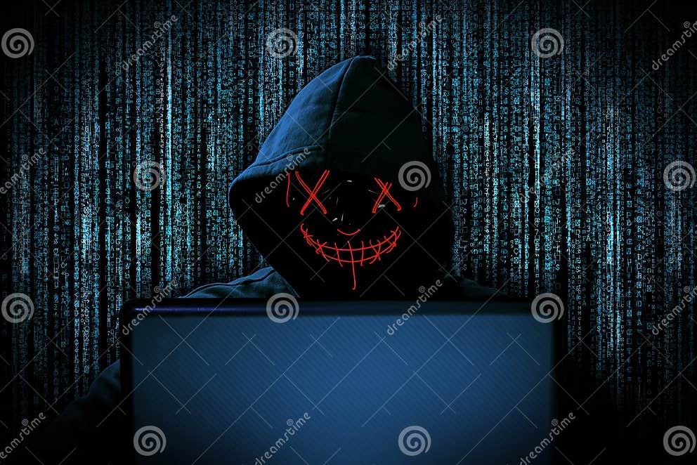 Hacker with Red Glowing Mask Behind Notebook Laptop in Front of Blue Source Binary Code ...