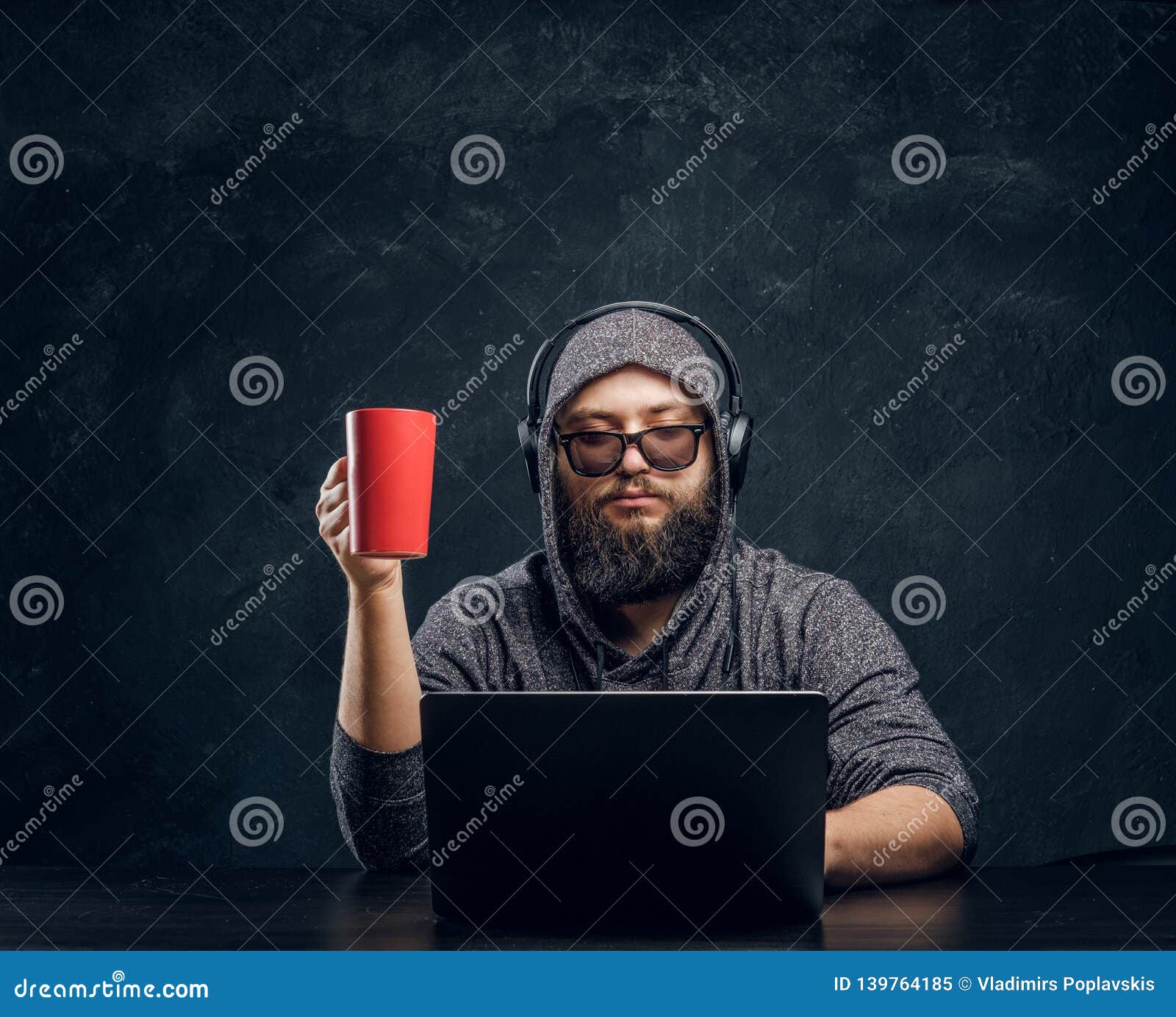 A Hacker Sits Behind a Laptop, Holding a Cup of Coffee and Working with ...