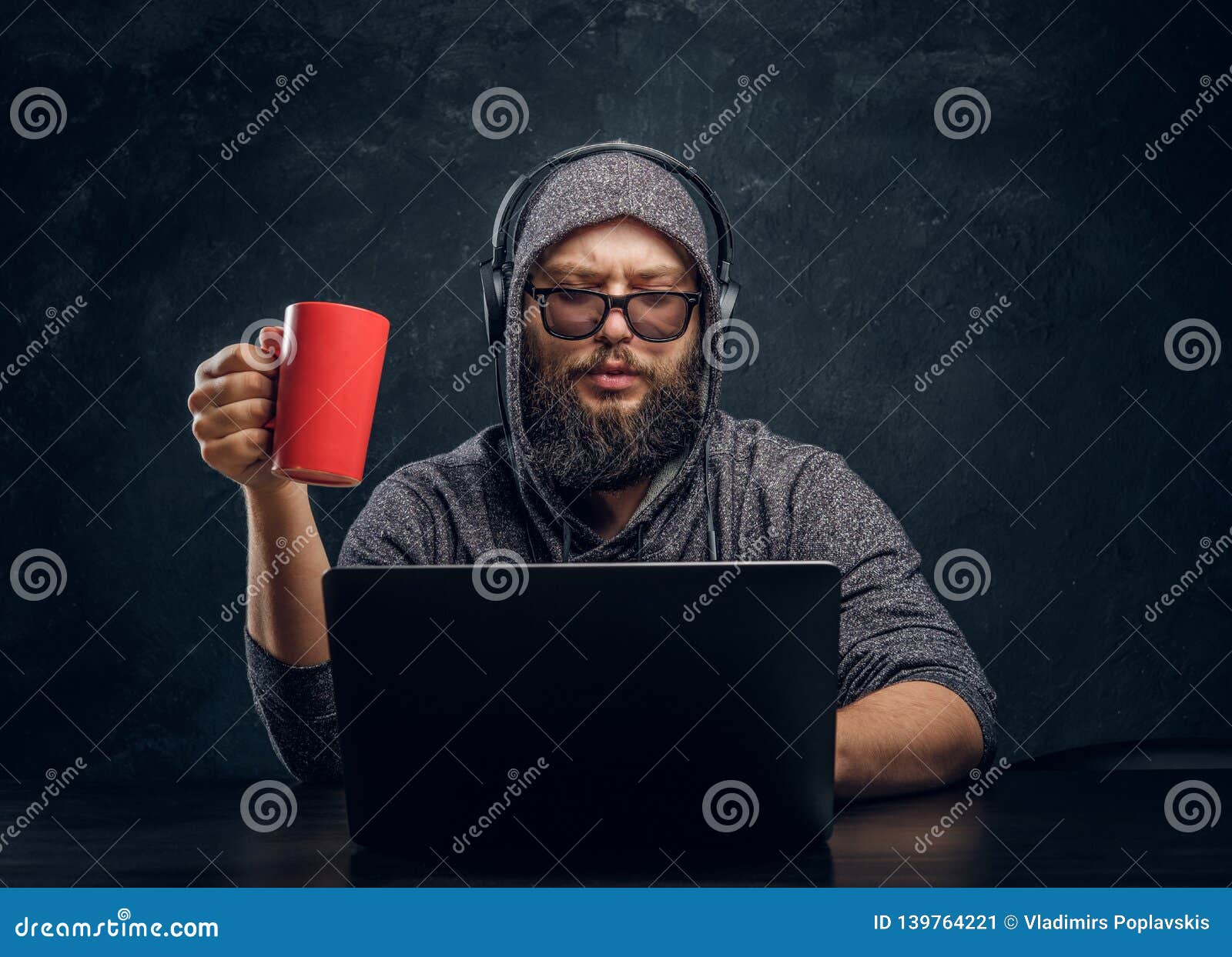 A Hacker Sits Behind a Laptop, Holding a Cup of Coffee and Working with ...