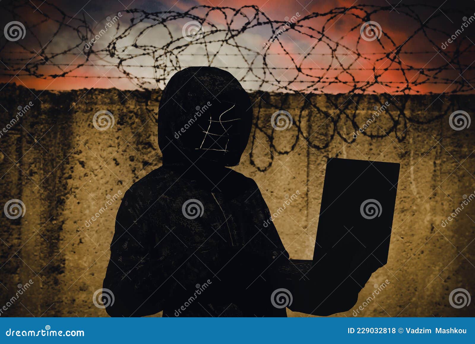 A Hacker Stands Against the Wall of a Prison with Barbed Wire ...