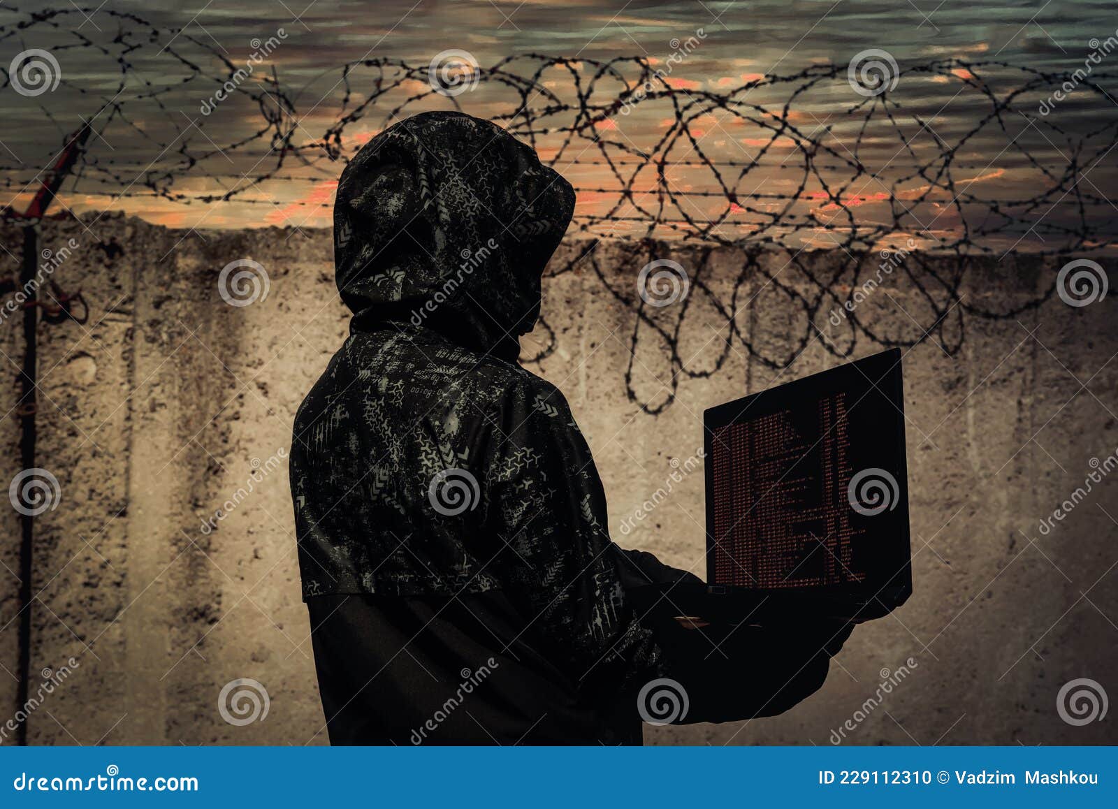 A Hacker Stands Against the Wall of a Prison with Barbed Wire ...