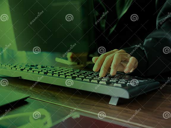 Hacker Typing On Keyboard With Dark Green Light Background Stock Image