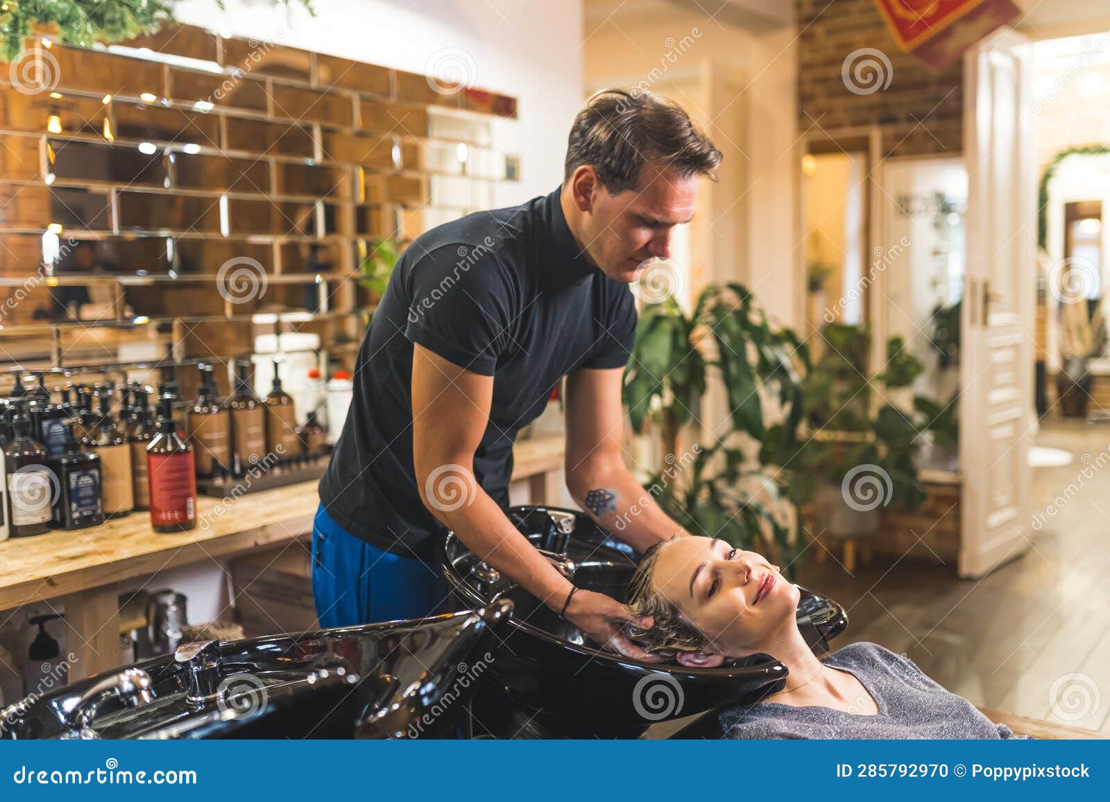 Hairdresser Shampooing His Client Hair At A Sink In A Barber Shop