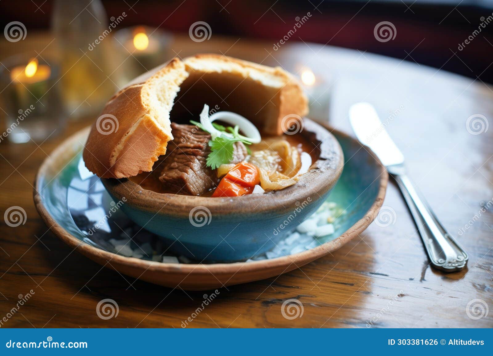 Half-eaten Goulash in Bread Bowl Showing Inside Texture on Table Stock ...