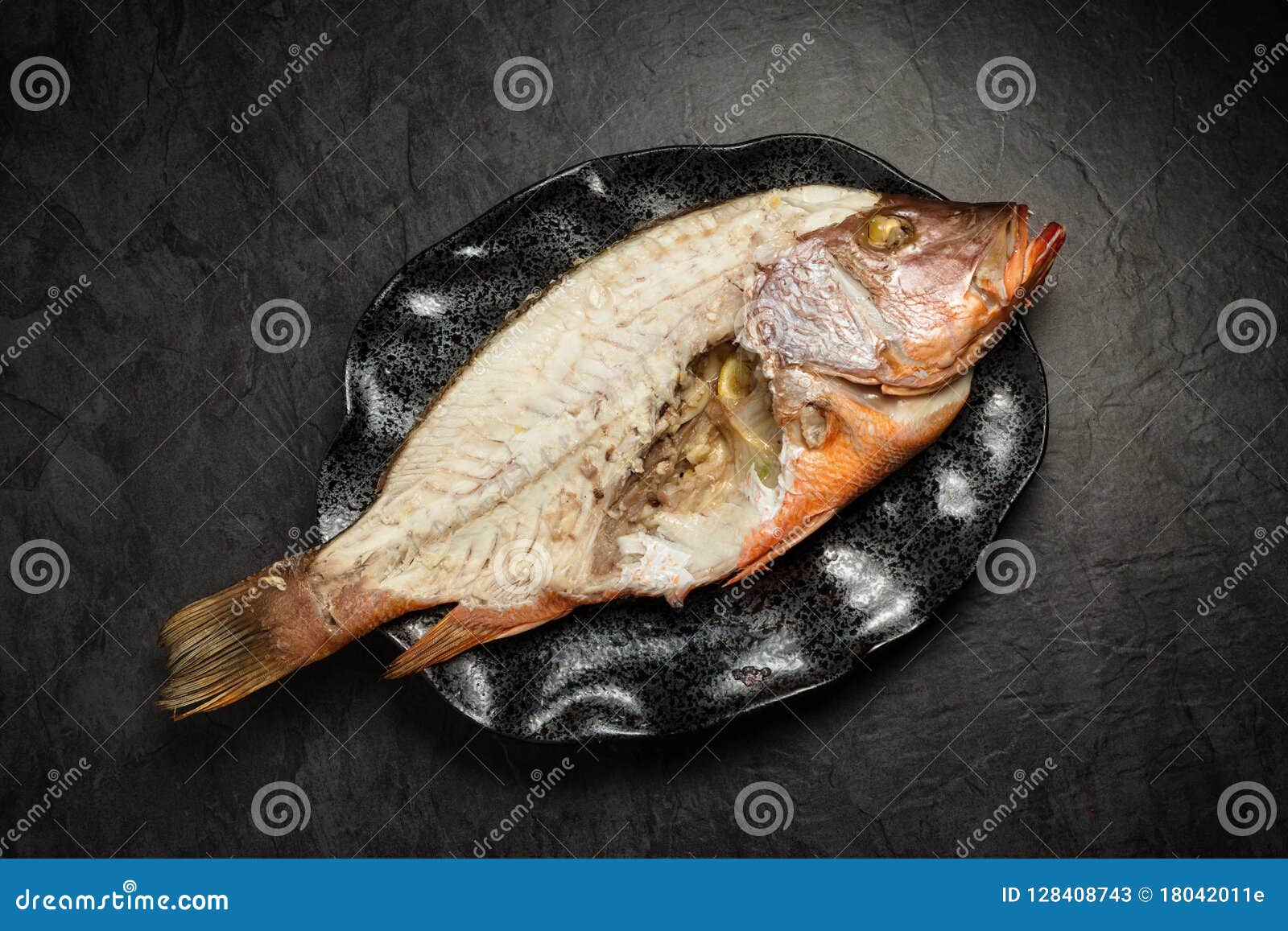 Half Eating Red Snapper with Exposed Bones, on Dark Background Stock ...