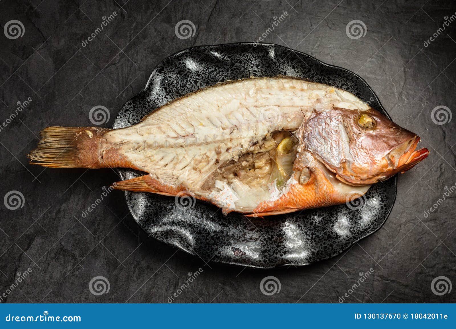 Half Eating Red Snapper Fish with Exposed Bones, on Dark Background ...
