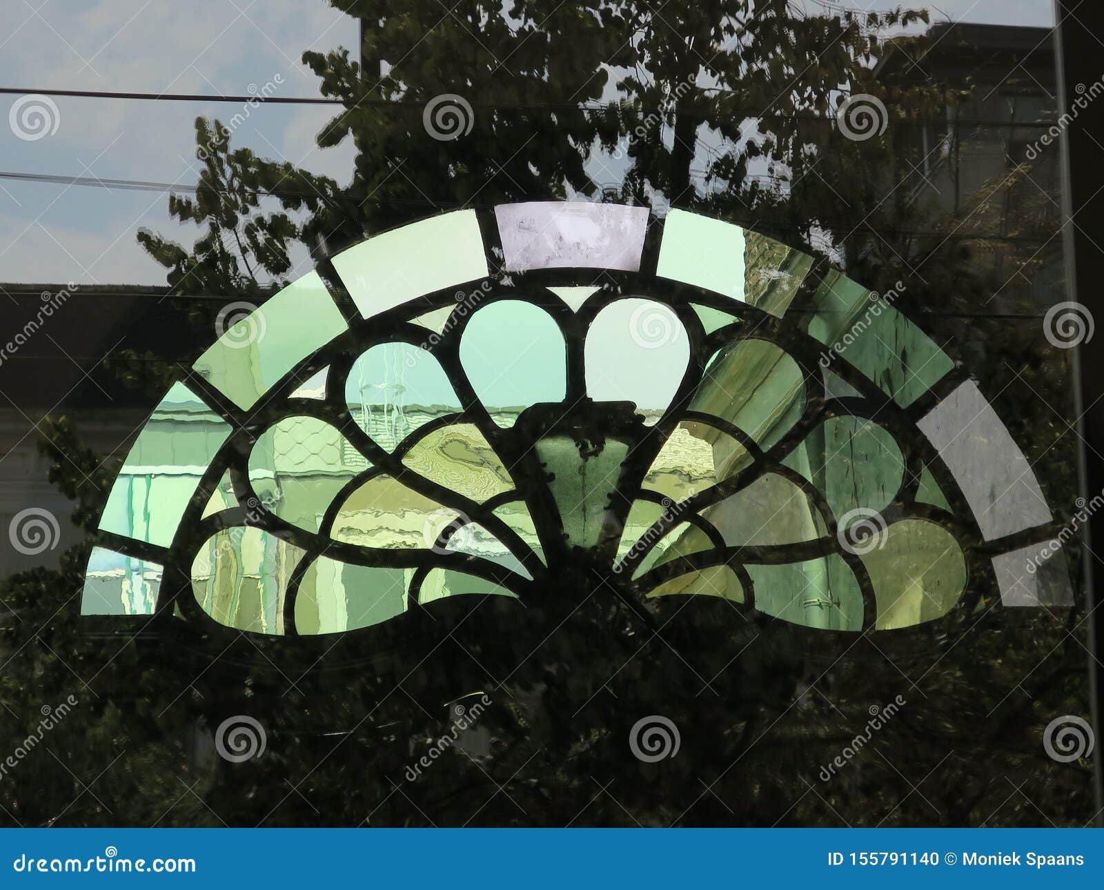 Half Round Window Above a Door Reflecting a Tree at the Other Side of ...