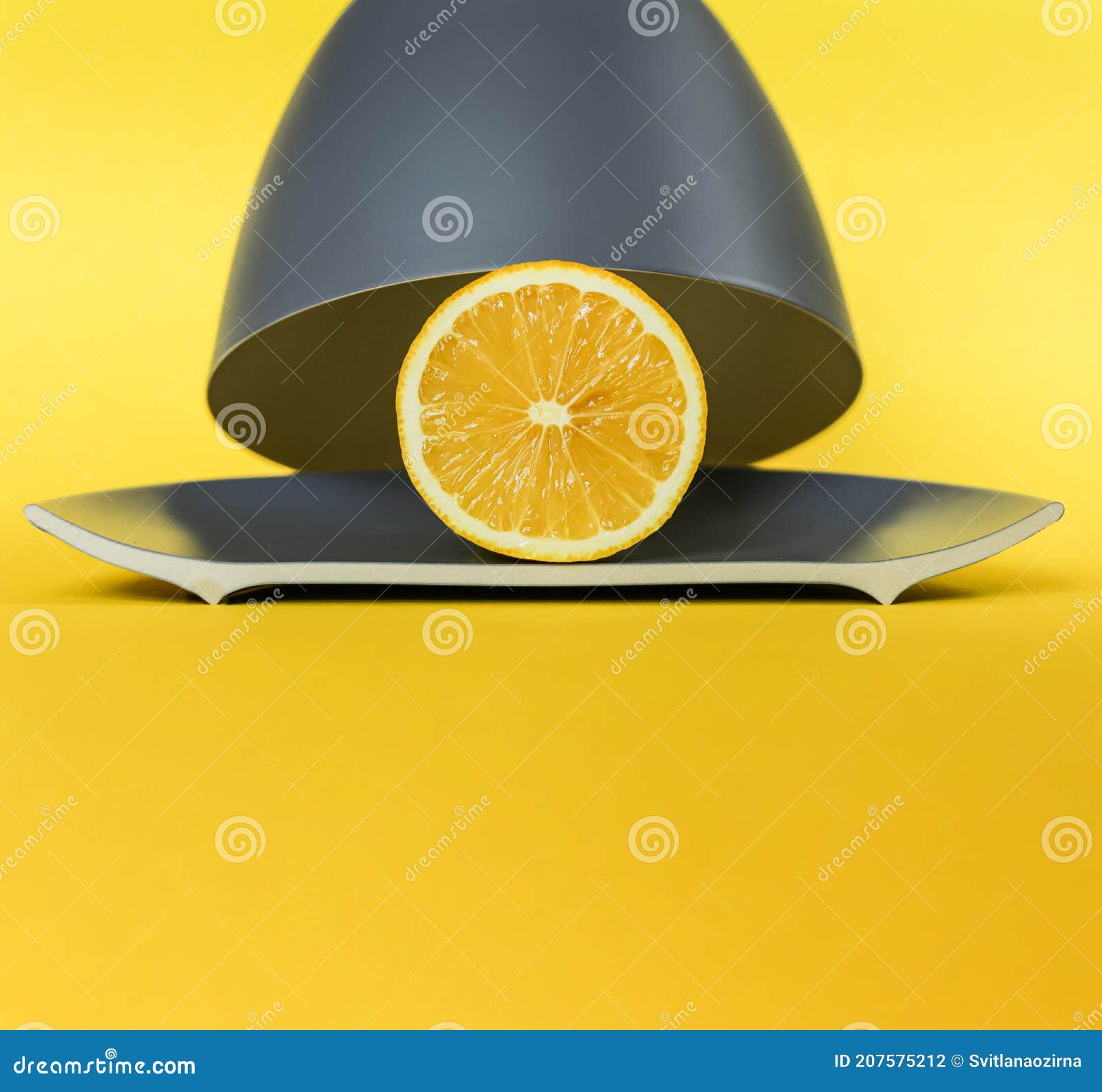 Half a Yellow Lemon Under the Hood on a Gray Plate on a Yellow ...