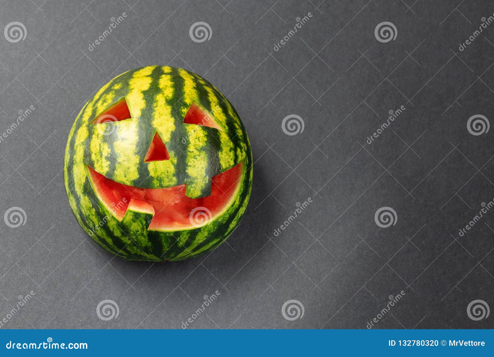 Halloween Watermelon with a Funny Face Closeup on a Dark Background ...