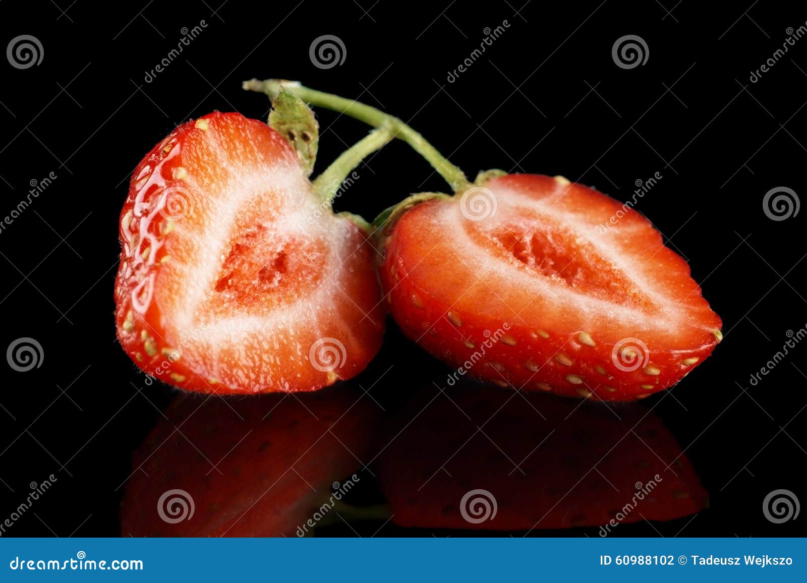 Halved Strawberry Isolated On Black With Green Stalk Stock Photo ...