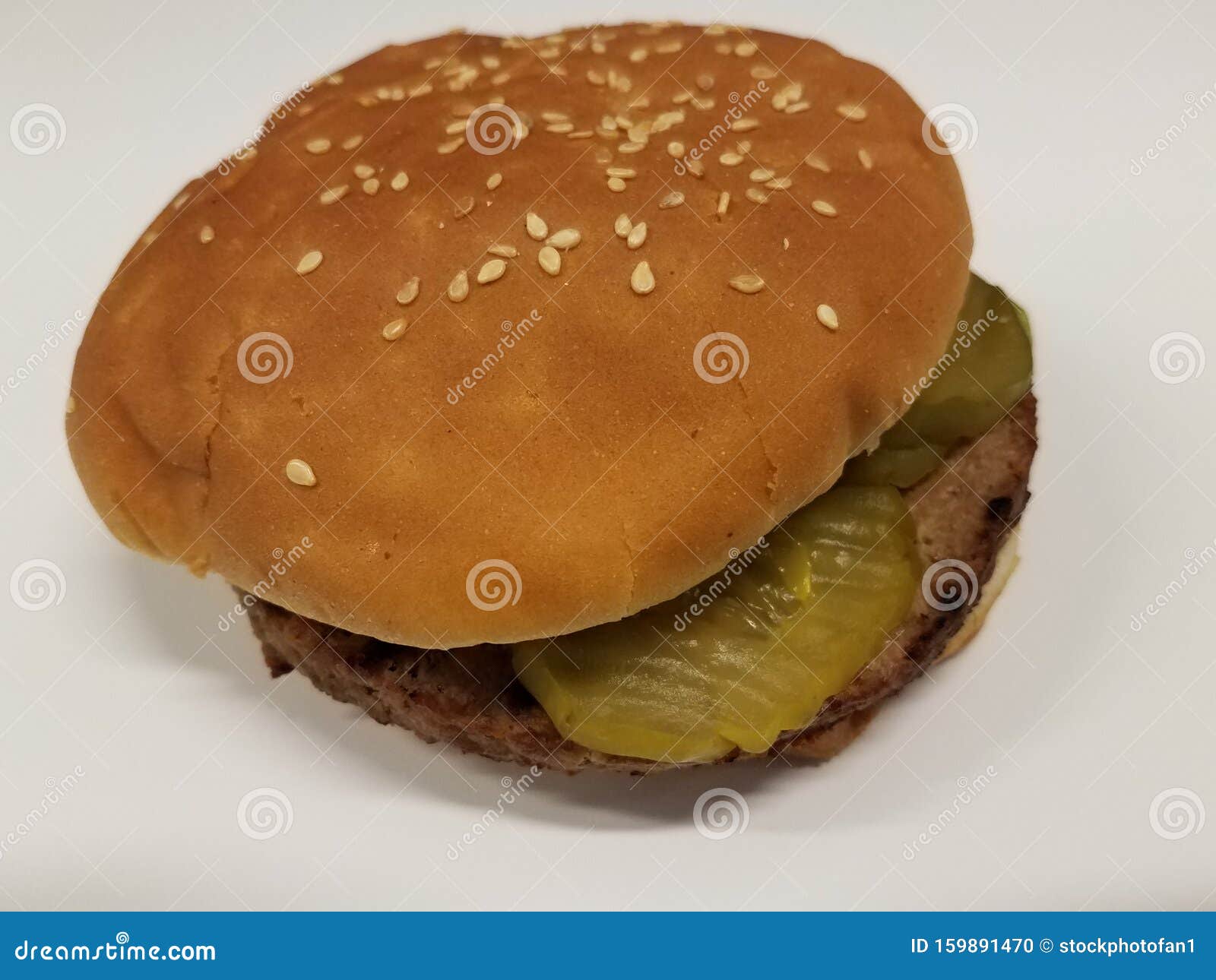 Hamburger with Bun and Pickle on White Table Stock Photo - Image of ...