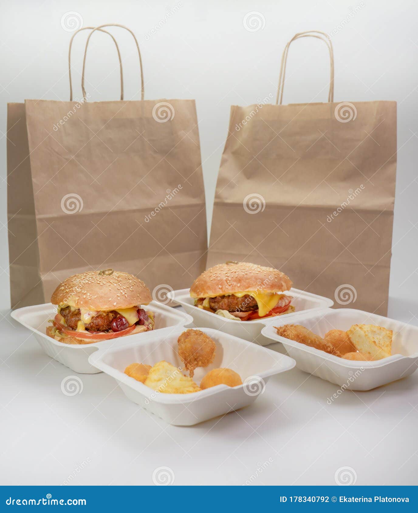 Hamburger in a Takeaway Container and a Paper Bag on a White Background ...