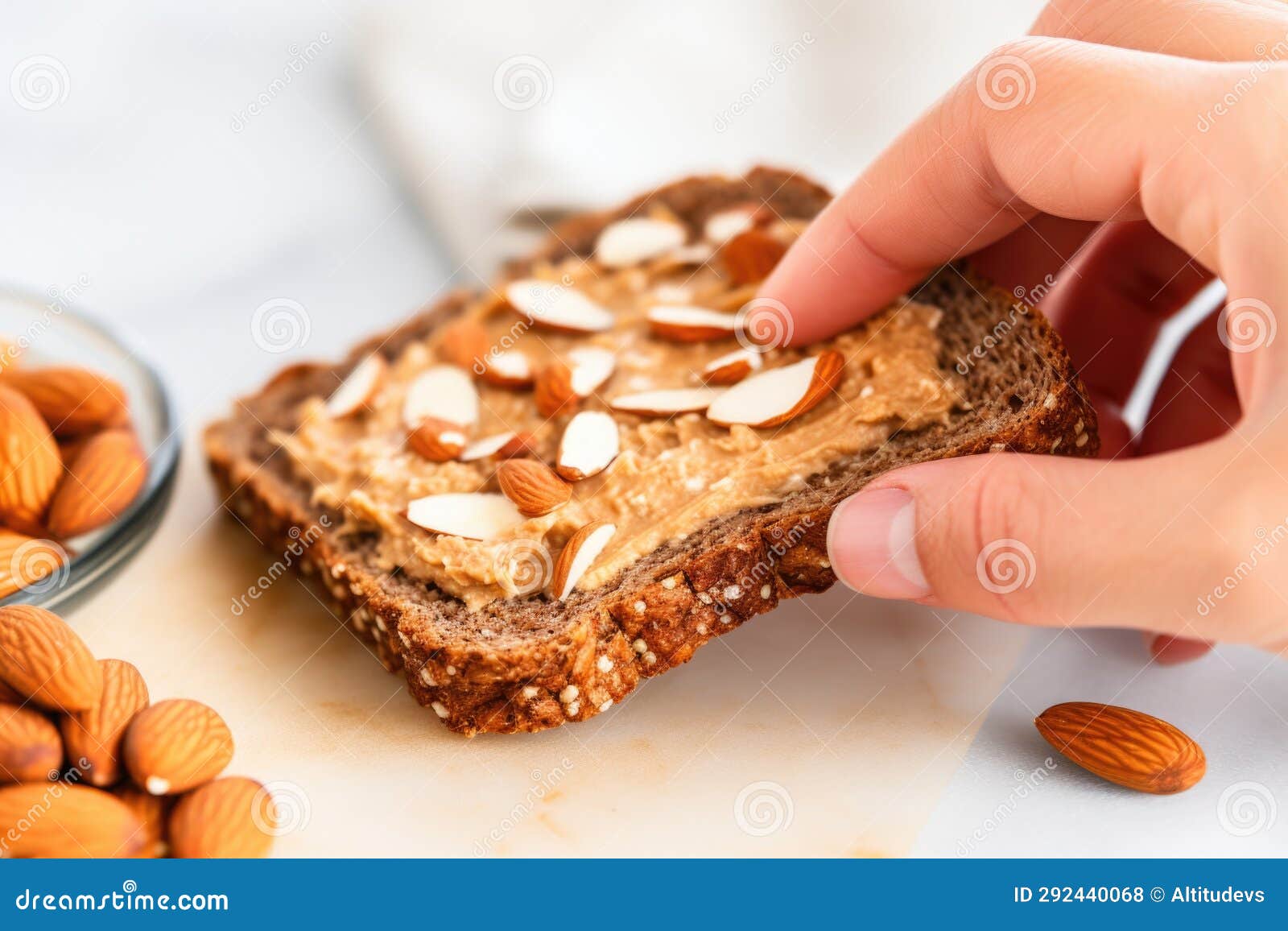Hand Adding a Dollop of Almond Butter on a Slice of Toasted Whole Grain ...