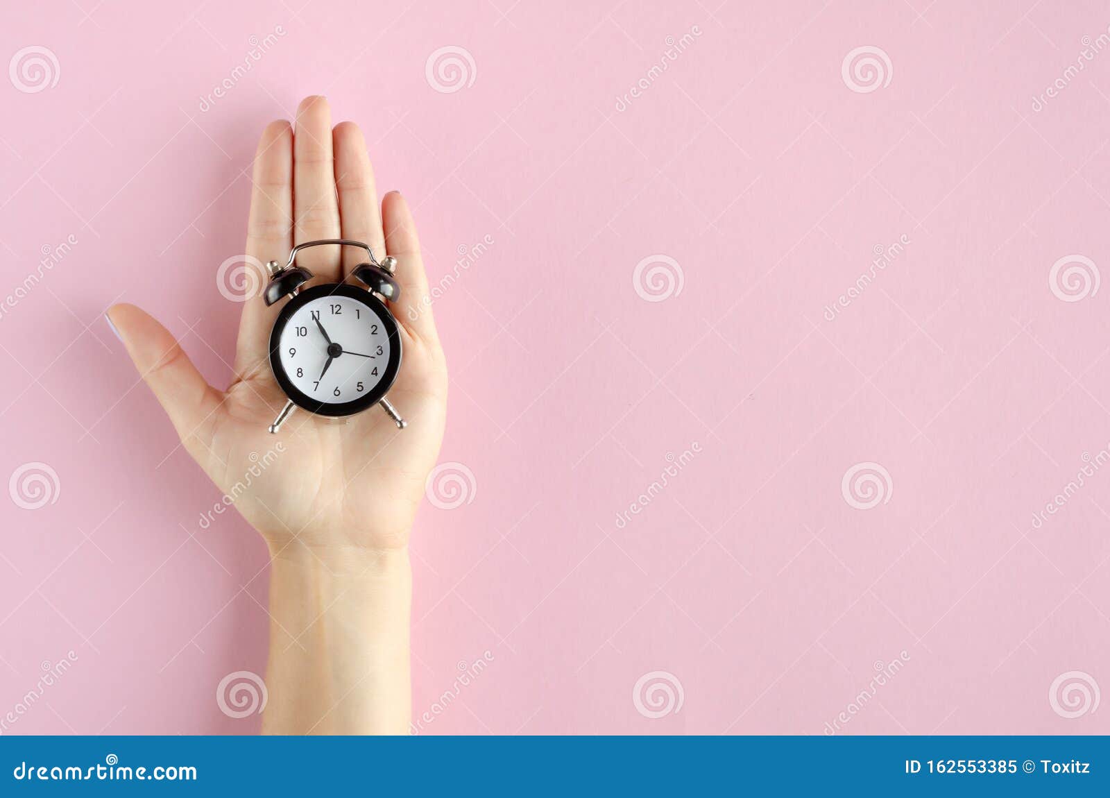 Hand with Analog Alarm Clock Composition on Pink Background Stock Image ...