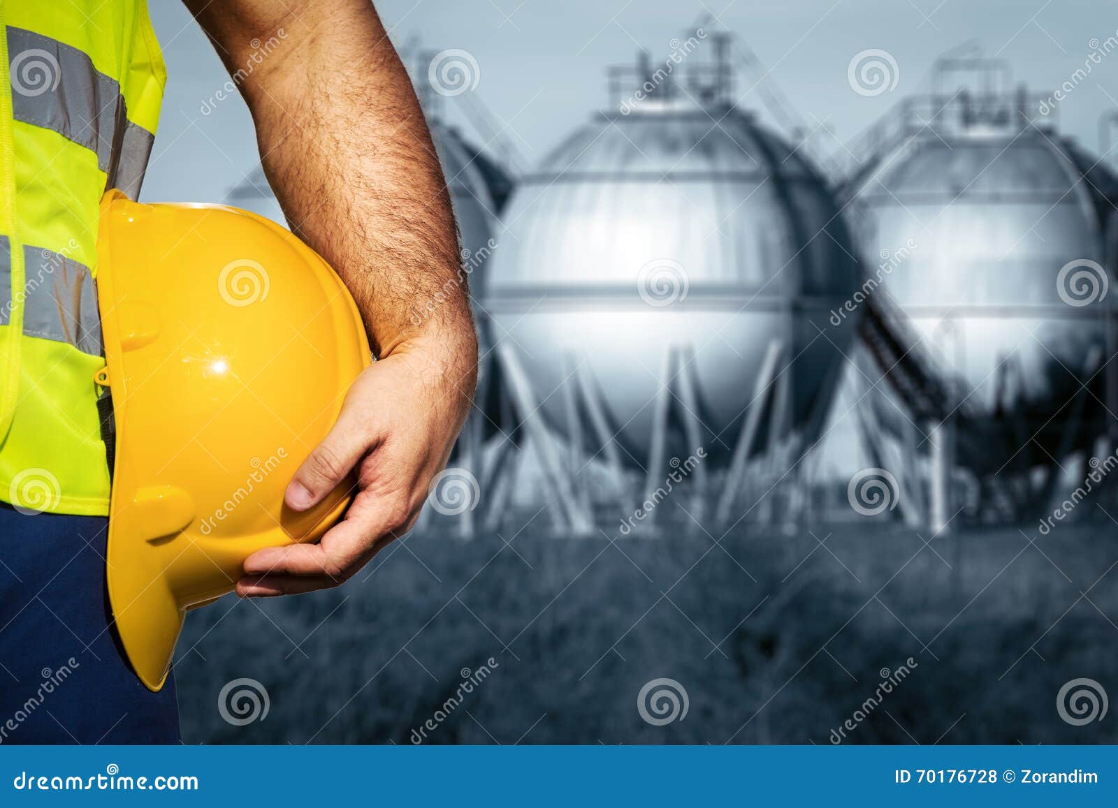 Hand or Arm of Engineer Hold Yellow Plastic Helmet in Front of Oil ...