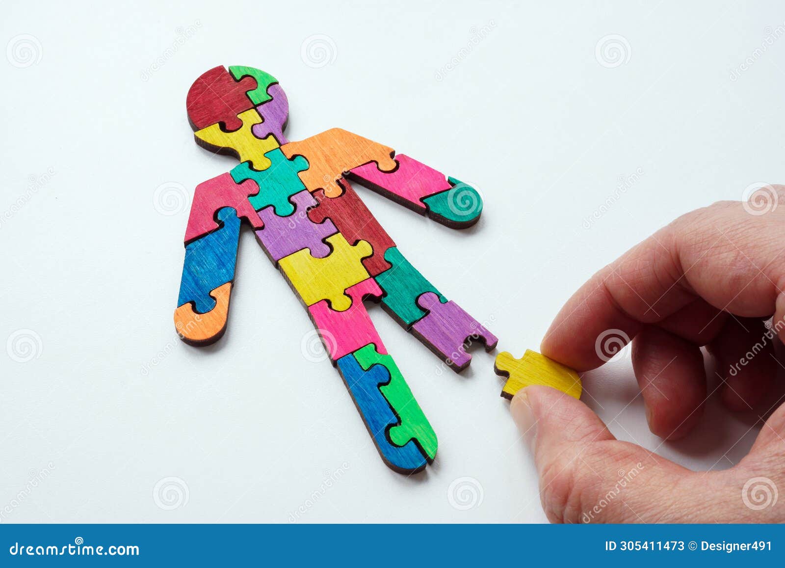 A Hand Assembles a Figure from Multi-colored Puzzles As a Concept of ...