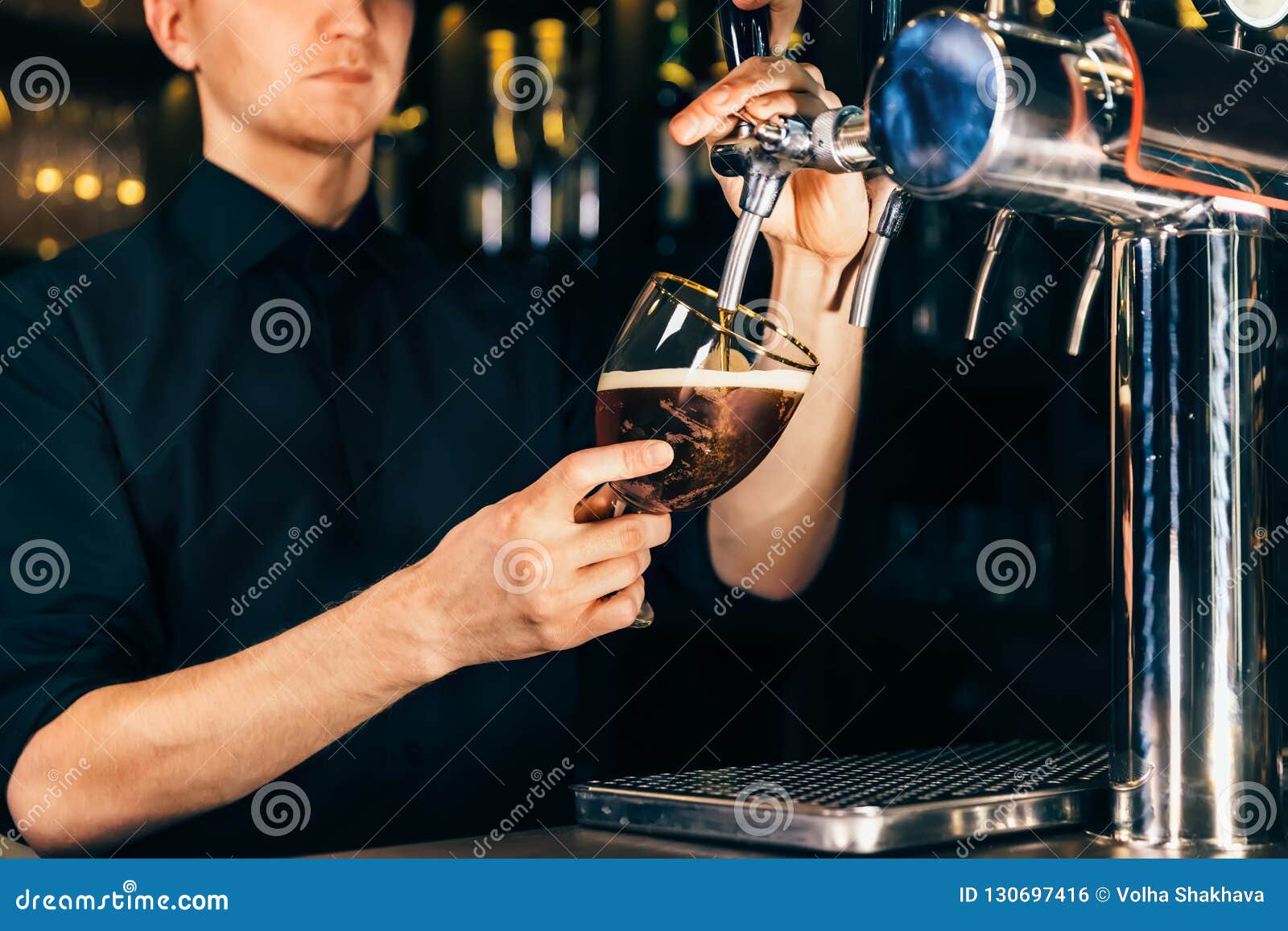 Hand of Bartender Pouring a Large Lager Beer in Tap in a Restaurant or ...