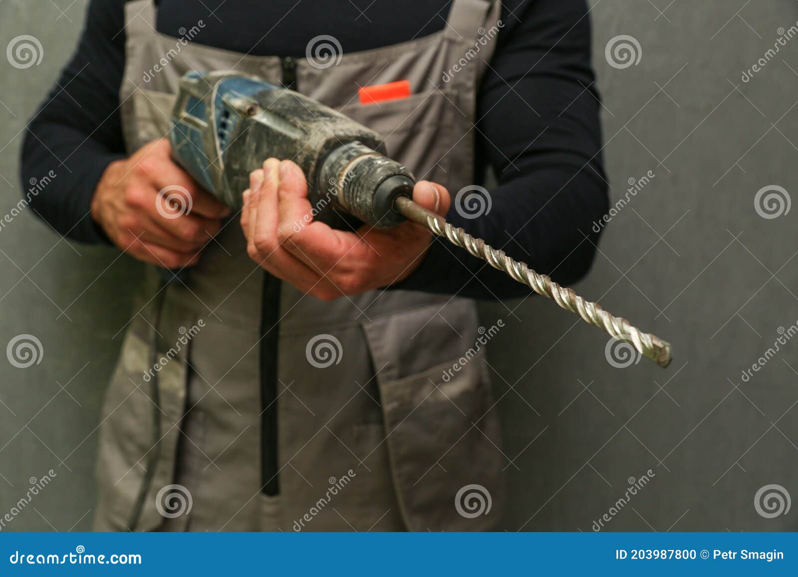 Hand of the Builder Holds a Hammer Drill on Background of Wall Stock ...