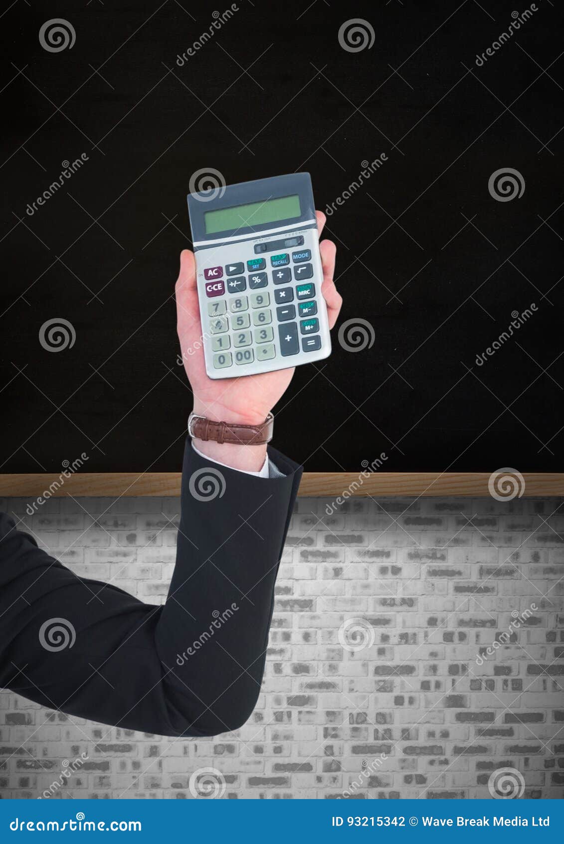 Hand with Calculator Against Black Chalkboard with White Brick Wall ...